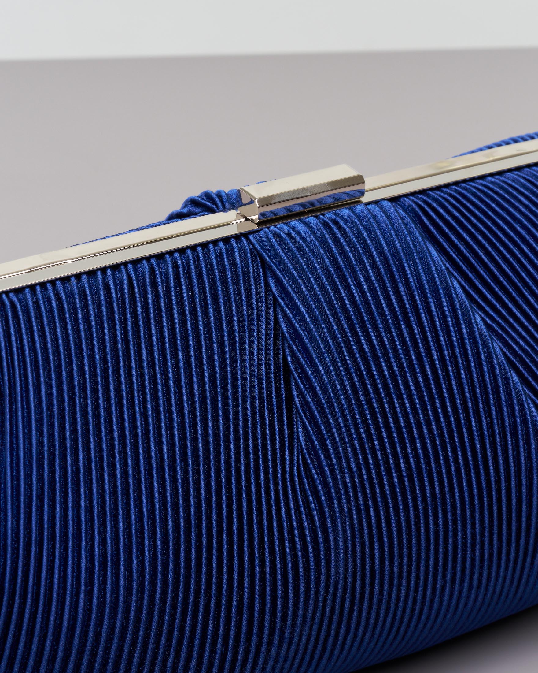 Clutch blu in raso plissè con pieghe e chiusura a scatto in metallo